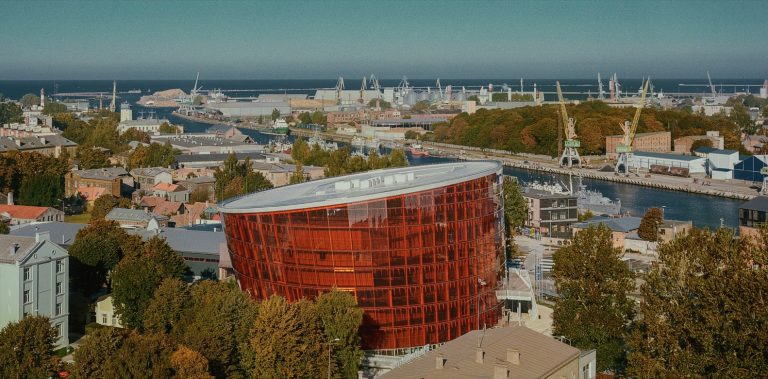 Great Amber Concert Hall enveloped by a tilted glazed facade
